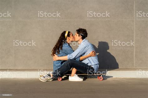 Photo Libre De Droit De Jeune Couple Aimant Assis Sur Un Longboard En