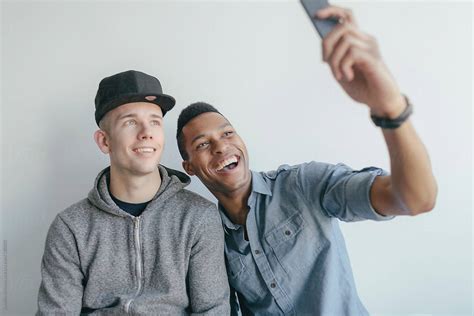 Two Men Friends Having Fun Taking Selfies With Smart Phone Camera App