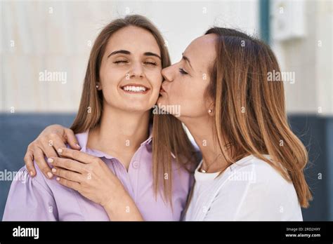 Two Women Mother And Daughter Hugging Each Other And Kissing At Street
