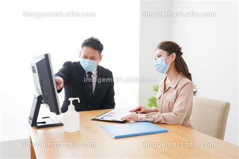 感染症対策をしてオフィスで働くビジネスパーソンの写真素材 [178250822] イメージマート