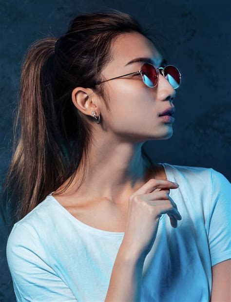 A Woman Wearing Sunglasses Is Posing For The Camera