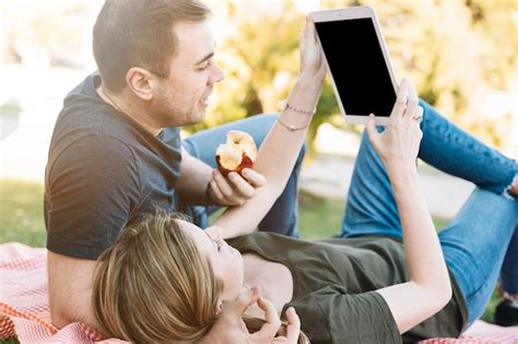 Free Photo Couple Browsing Tablet On Picnic