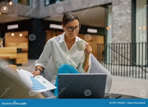 Smiling Female Analyst Drinks Coffee Working With Documents And Use