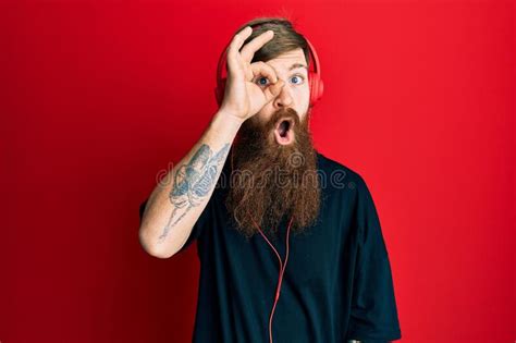 Redhead Man With Long Beard Listening To Music Using Headphones Doing