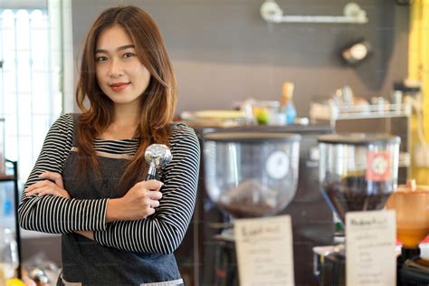 매력적인 아름다움 아시아 여성 바리 스타가 카운터 앞에 서서 포터 필터 커피 필터를 들고 커피 숍 카페 사진