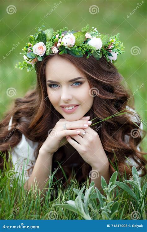 Fjädra Ståenden Av En Härlig Kvinna I En Krans Av Blommor Arkivfoto