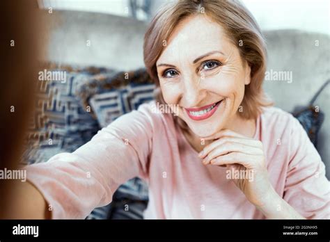 Beautiful Middle Aged Woman In Casual Clothes Is Making Selfie Stock