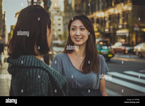 Two Girlfriends Meeting Outdoors And Having Fun Japanese People