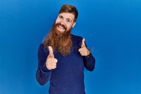 Redhead Man With Long Beard Wearing Casual Blue Sweater Over Blue