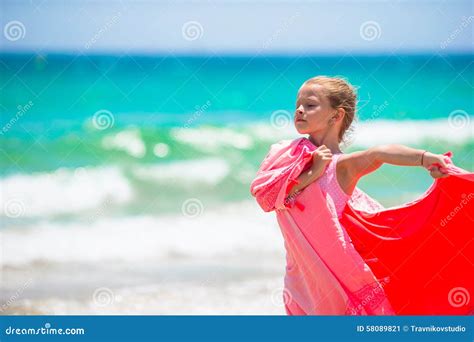 Lilla Flickan Har Gyckel Med Strandhandduken Under Fotografering För