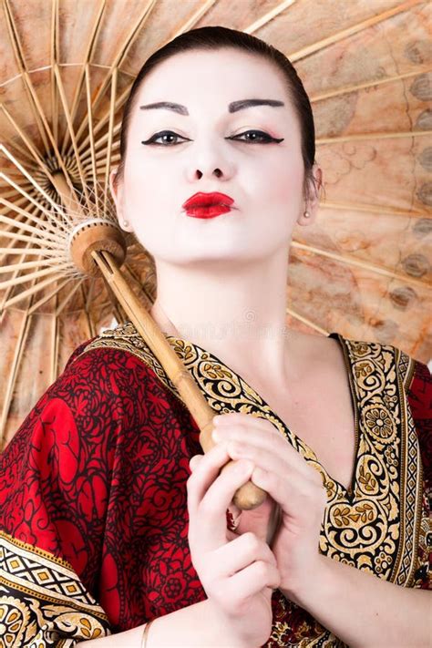 Beautiful Girl Dressed As A Geisha Girl Holding A Chinese Umbrella