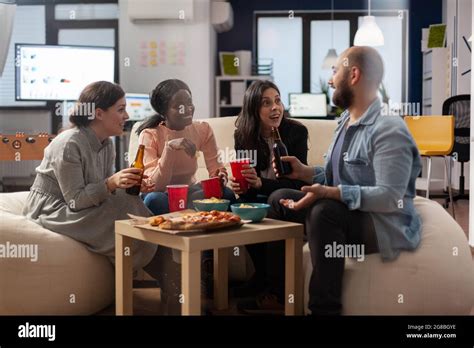 Multi Ethnic Colleagues Having Fun After Work At Office While Eating