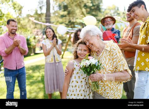 Beautiful Senior Birthday Woman Receiving Flowers From Granddaughter