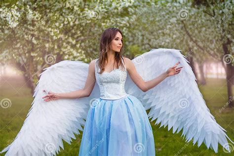 Woman In A White Corset And A Blue Puffy Dress With Large White Angel