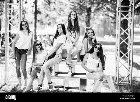 Six Wonderful Model Girls Posing On Wooden Boxes In The Park On A Sunny