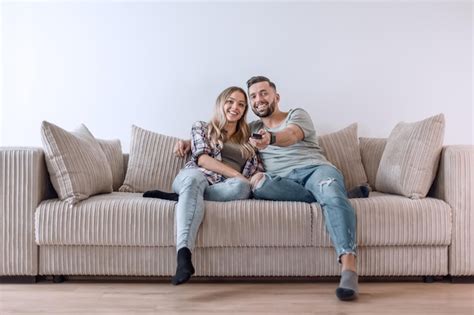 Premium Photo Young Couple Enjoying Themselves On The Sofa In The