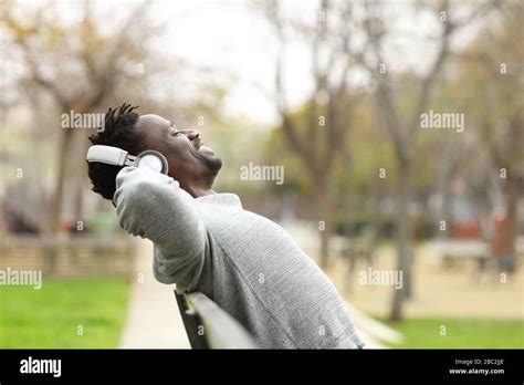 Side View Portrait Of A Black Man Wearing Wireless Headphones Relaxing