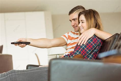 لطيف زوجين الاسترخاء على الأريكة مشاهدة التلفزيون مسكن أنثى القوقاز