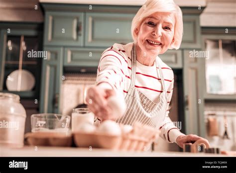 Positive Delighted Granny Cooking Biscuits For Granddaughter Stock