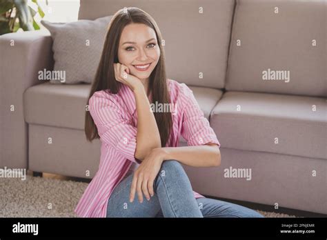 Photo Of Pretty Happy Nice Young Lady Sit Floor Hold Hand Cheekbone