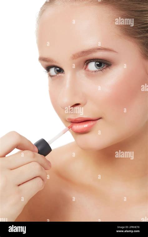 Fulling Out Her Lips A Stunning Young Woman Applying Lipgloss To Her