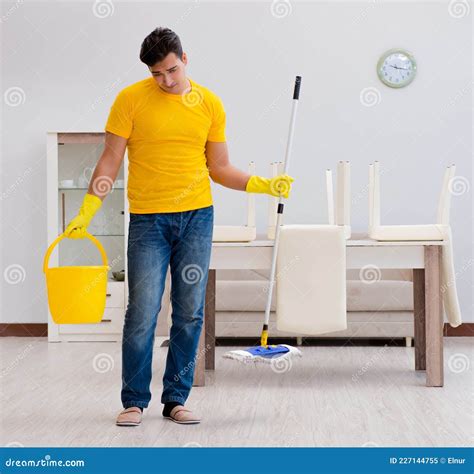 Hombre Limpiando La Casa Ayudando A Su Esposa Imagen De Archivo
