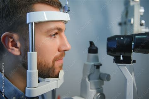 Adult Man Eyesight Test With Binocular Slit Lamp Checking Retina Of A