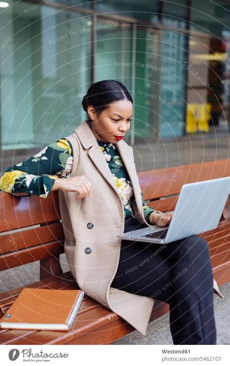 Businesswoman Sitting On Bench Using Laptop A Royalty Free Stock