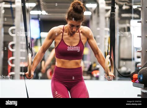 Athletic Woman Doing Some Pull Up Exercises In The Gymnastic Rings In A