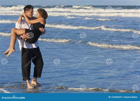 Man Carrying Woman In Romantic Embrace On Beach Royalty Free Stock