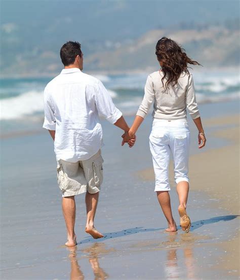 Beautiful Couple Walking Hand In Hand On The Beach On A Romantic