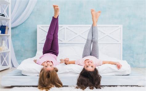 Duas Garotas Deitada Na Cama Com As Pernas Cruzadas Em Casa Foto Grátis