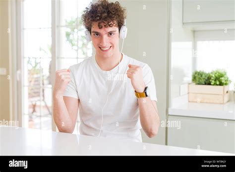 Young Man Listening To Music Wearing Headphones At Homes Celebrating