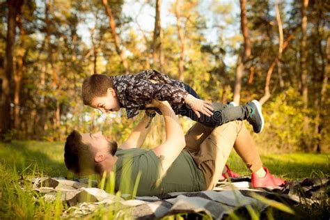 Father And Son Walking And Having Fun In Autumn Forest Look Happy And