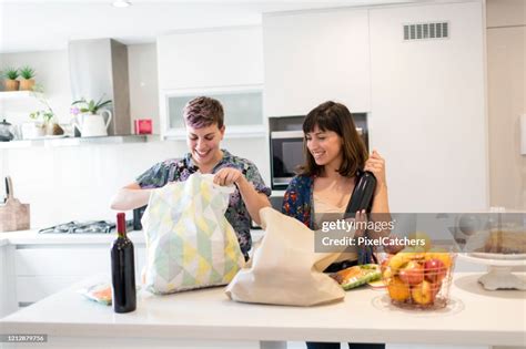 Happy Lesbian Couple Unpacking Reusable Shopping Bags High Res Stock