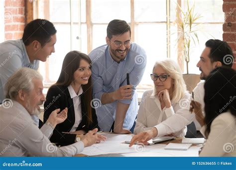 Happy Diverse Business Team Talking Brainstorming Gathered At Table