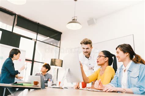 Happy Diverse Office Workers Team Laughing Together At Group Meeting