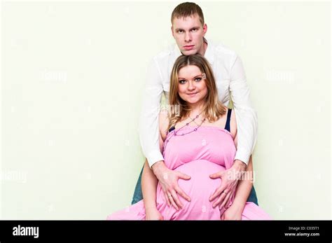 Pregnant Woman With Her Husband Sitting On Chair Caucasians A Loving