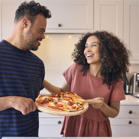 Couple At Home With Man With Down Syndrome And Woman Holding Homemade