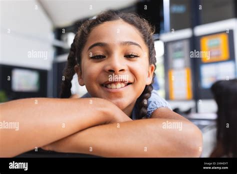Biracial Girl With Braided Hair Smiles Warmly Resting Her Chin On Her