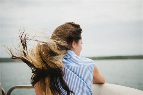 Girl On Lake With Wind Blowing Through Hair By Stocksy Contributor