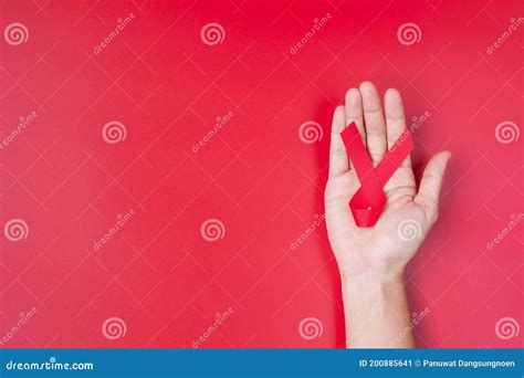 Hand Holding Red Ribbon For Supporting People Living And Illness