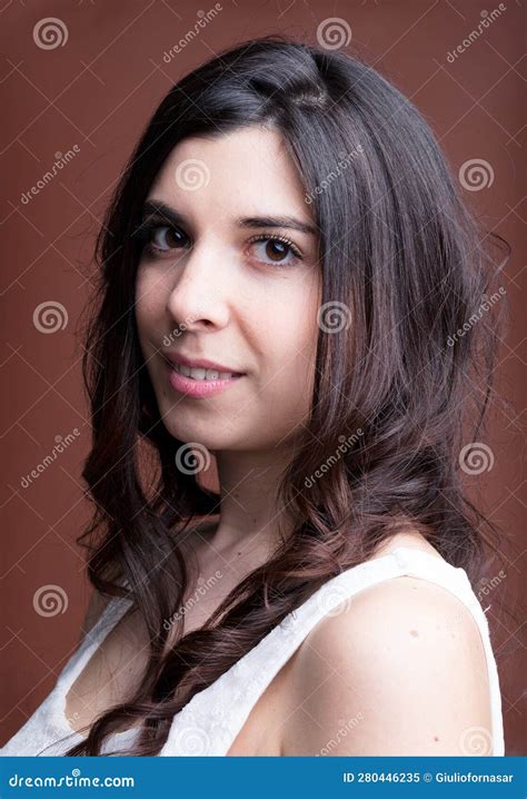 Pale Skinned Mediterranean Woman Smiles On Brown Backdrop Stock Image