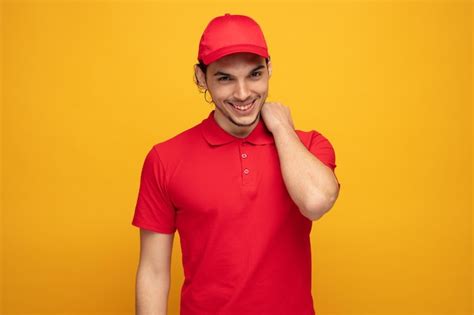 Premium Photo Shy Young Delivery Man Wearing Uniform And Cap Looking