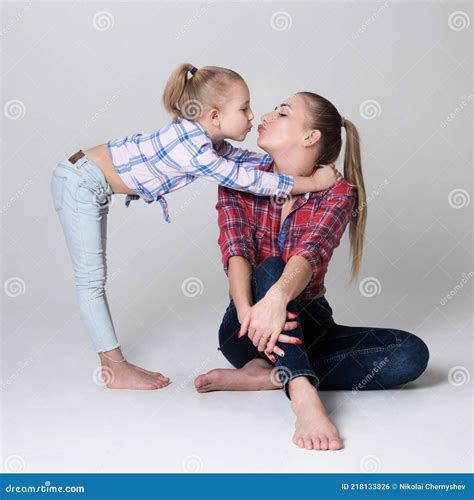 Athletic Mom And Daughter Show Hair While Sitting On Chair And Floor