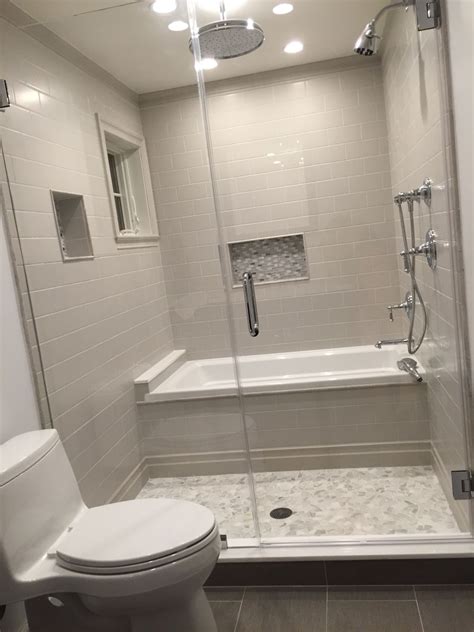 A White Toilet Sitting Next To A Bath Tub In A Bathroom Under Lights
