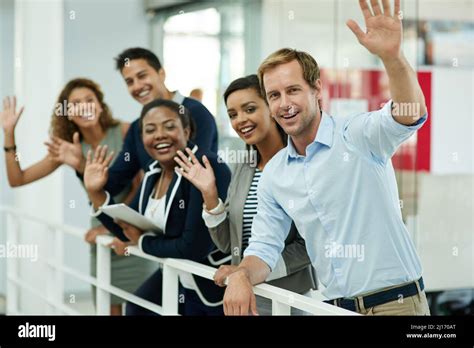 Hello Success Portrait Of A Group Of Smiling Coworkers Waving While