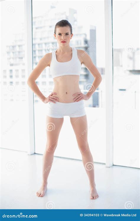 Frowning Fit Brown Haired Model In Sportswear Posing With Hands On The