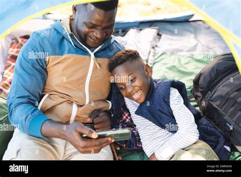 African American Father And Son Share A Moment Inside A Tent Looking