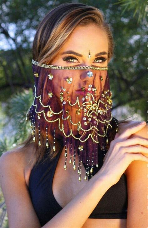 A Woman With Her Face Covered In Beads And Chains Posing For The